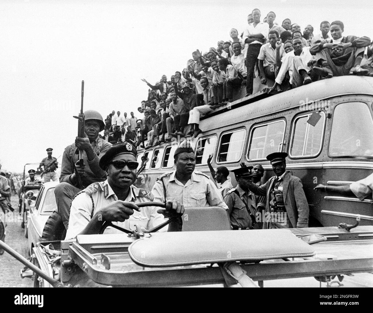Major General Idi Amin drives his Jeep to attend a ceremony following ...
