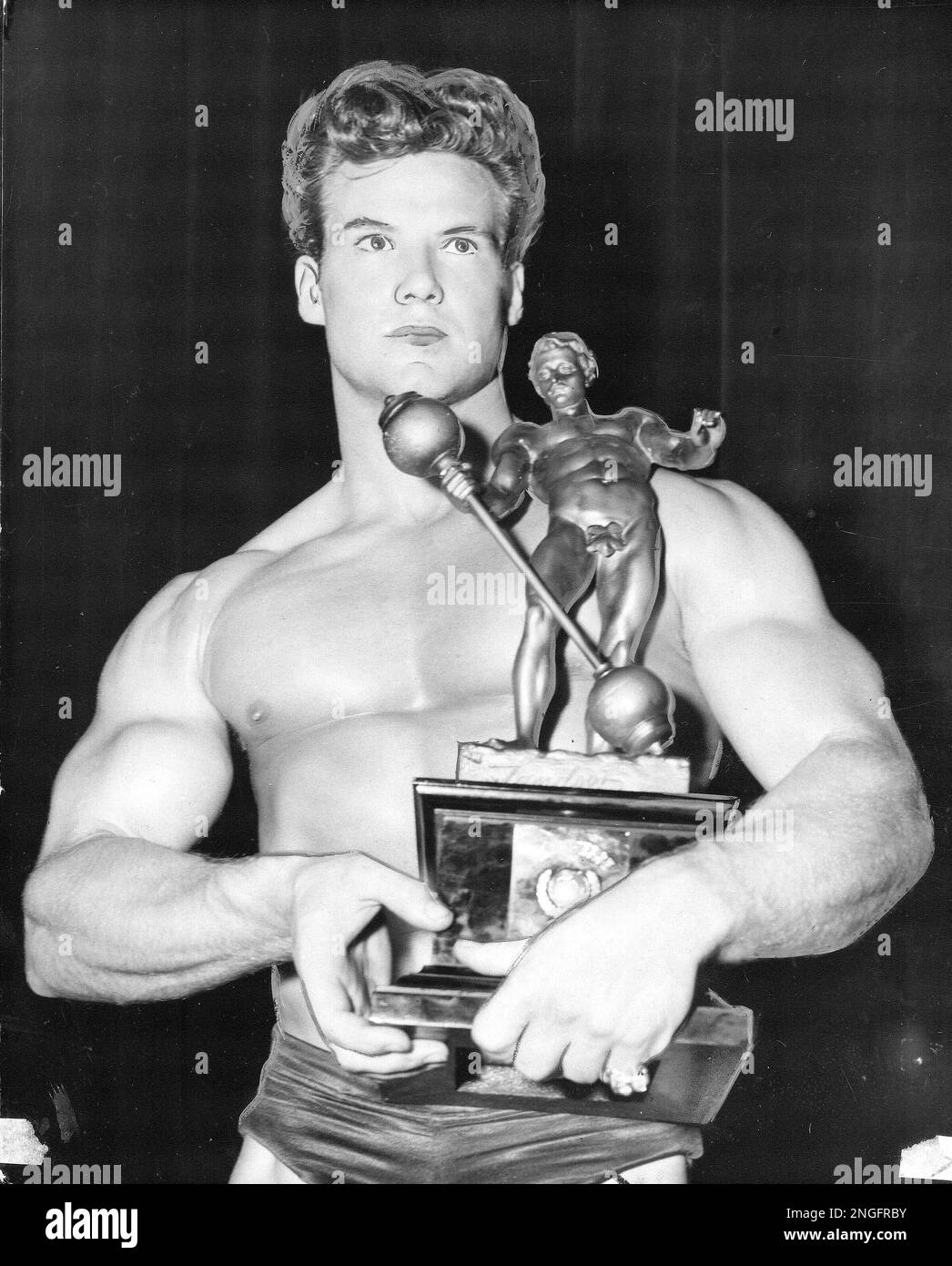 24-year-old American bodybuilder Steve Reeves poses with the trophy ...