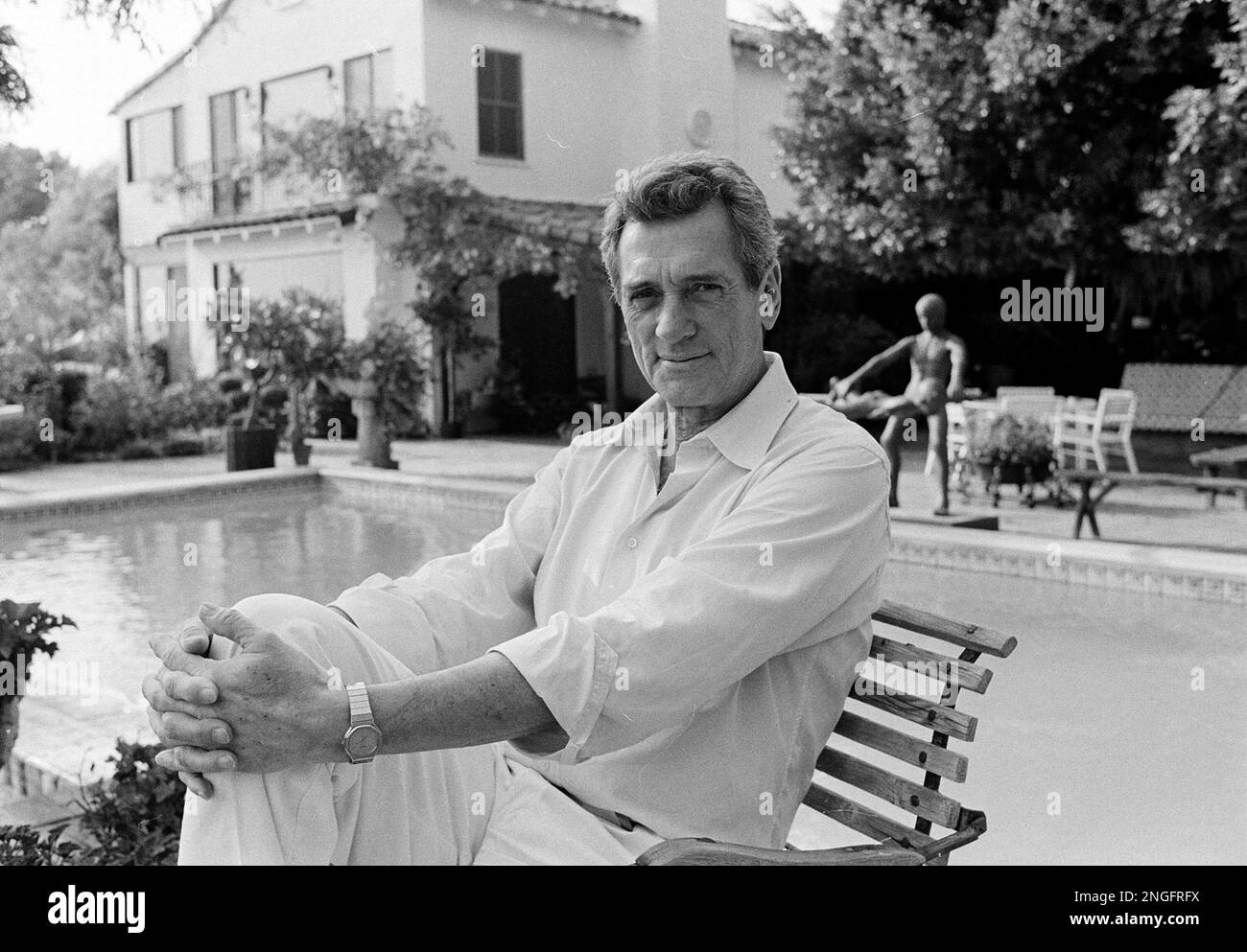 Actor Rock Hudson poses by the swimming pool in his backyard at home in ...