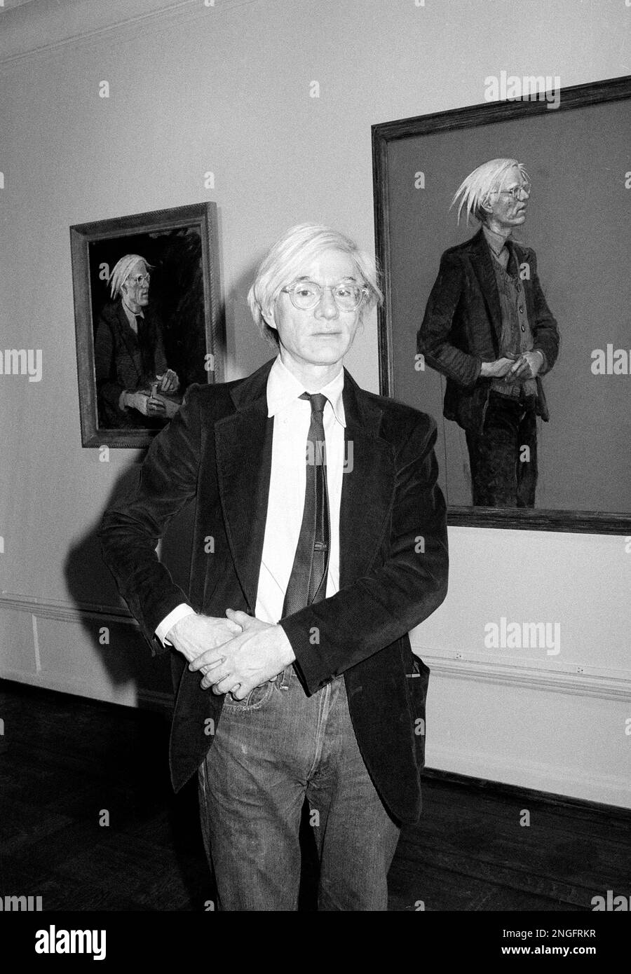 Pop artist Andy Warhol poses in front of a portrait of himself at the ...