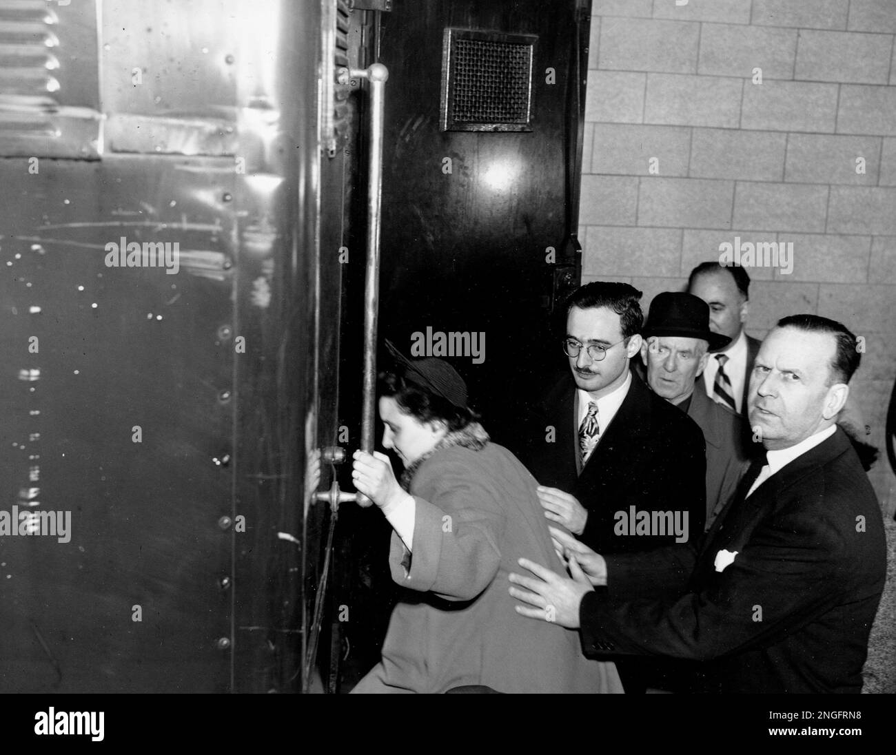 Ethel Rosenberg and her husband, Julius, wearing eyeglasses, climb into ...