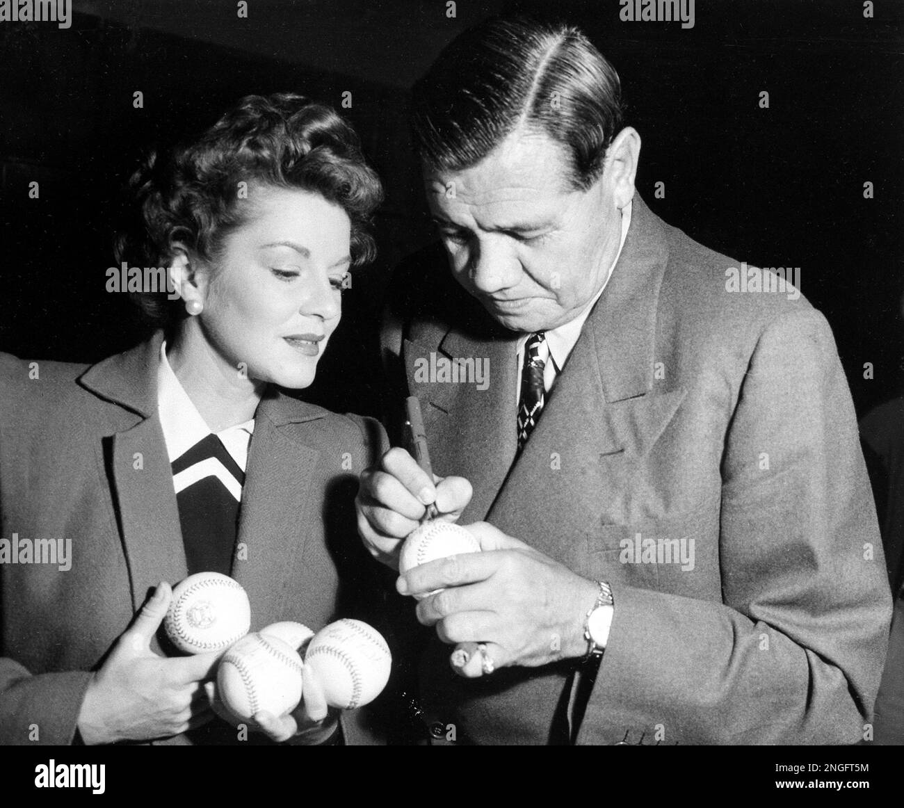 Baseball great Babe Ruth is signing a baseball for actress Claire ...