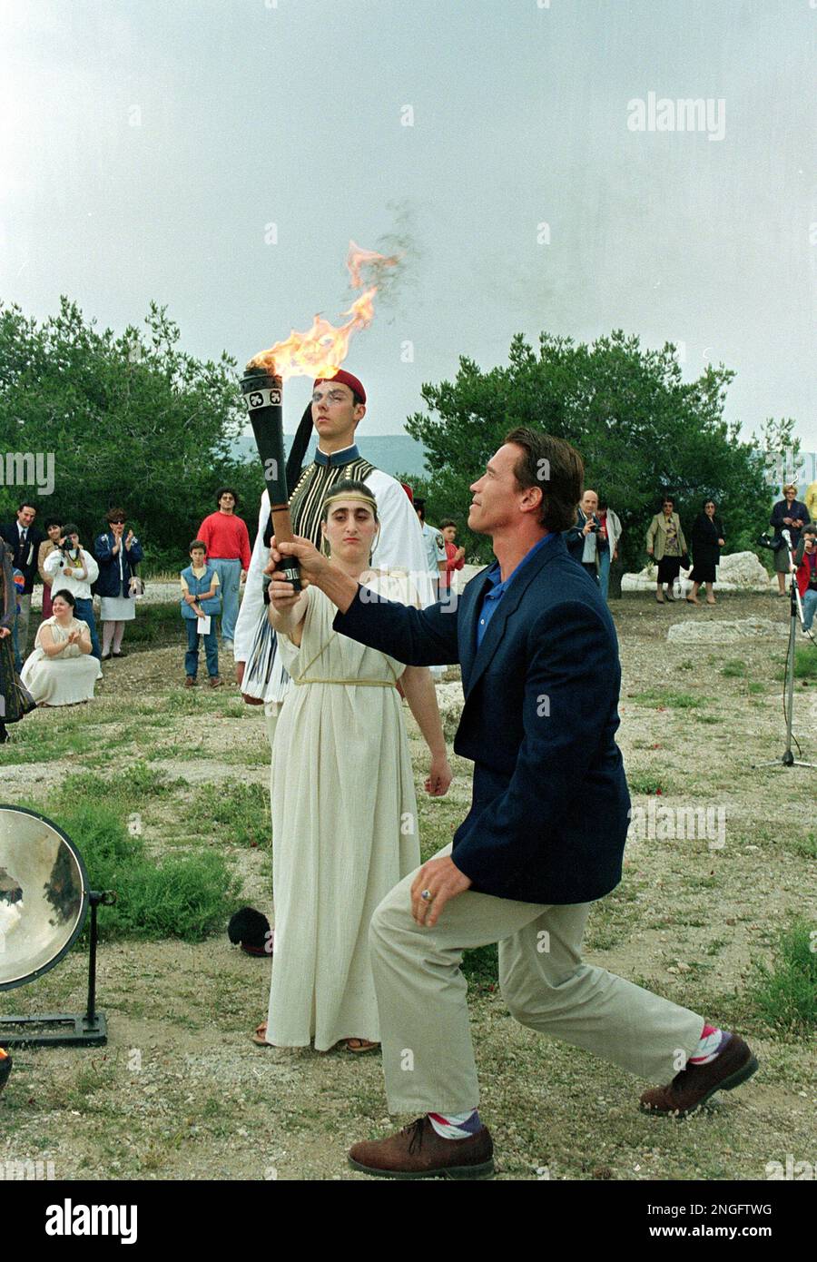 Hollywood action star Arnold Schwarzenegger takes a torch, lit from the ...