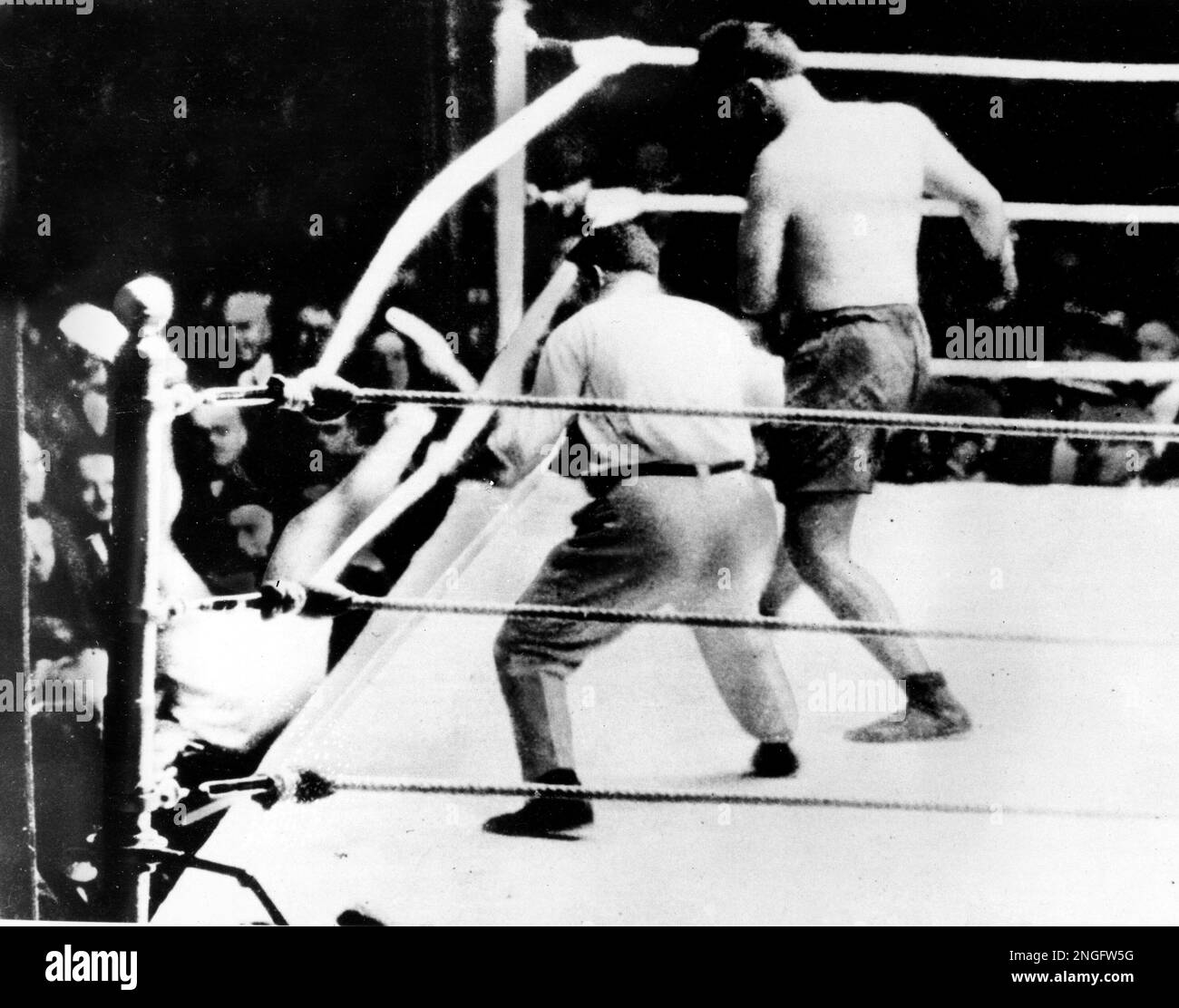 Jack Dempsey falls through the ropes during the heavyweight fight ...