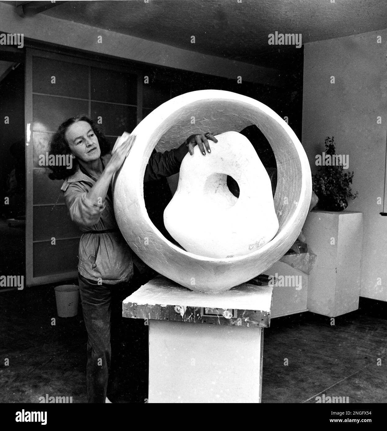British sculptor Barbara Hepworth demonstrates the open feeling of her ...