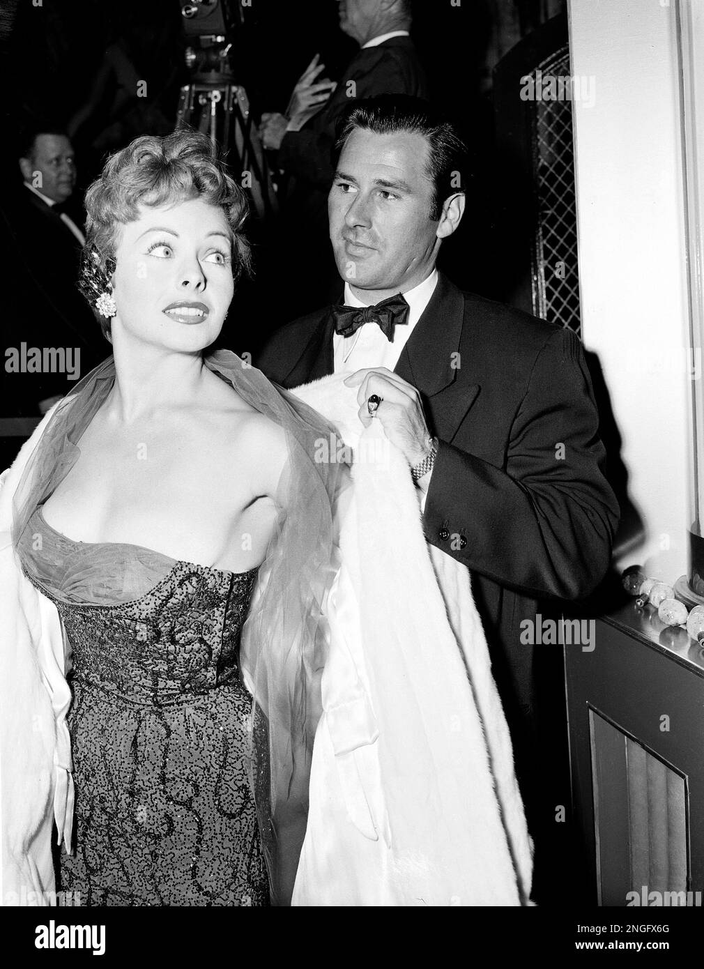 Actress Jeanne Crain is helped out of her fur coat by her husband ...