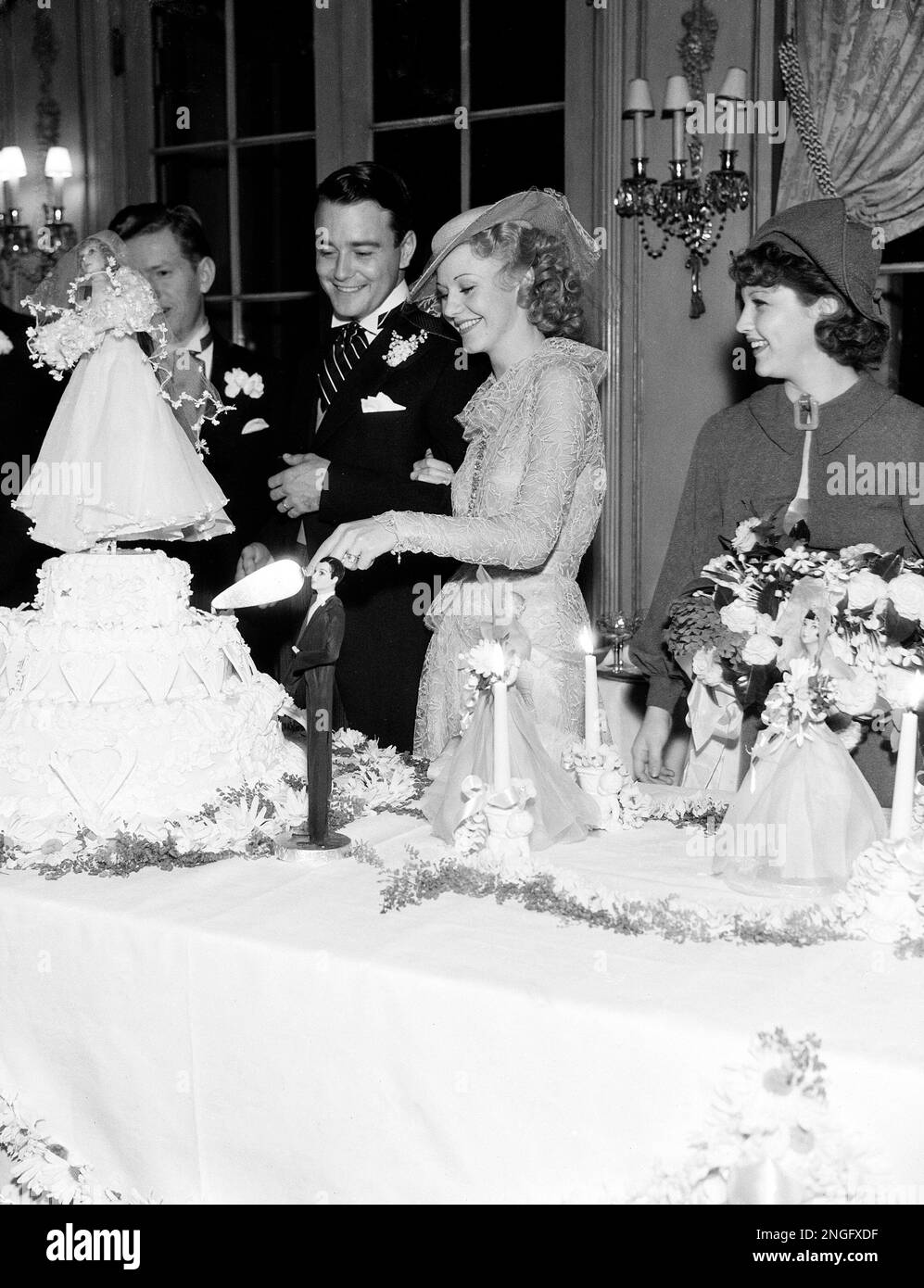 Actress Ginger Rogers and actor Lew Ayres cut their wedding cake at the ...