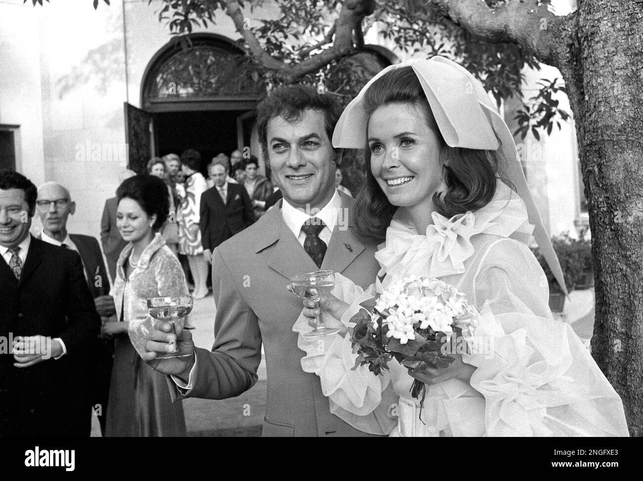 Actor Tony Curtis, 41, and his bride, model Leslie Allen, 23, toast as ...