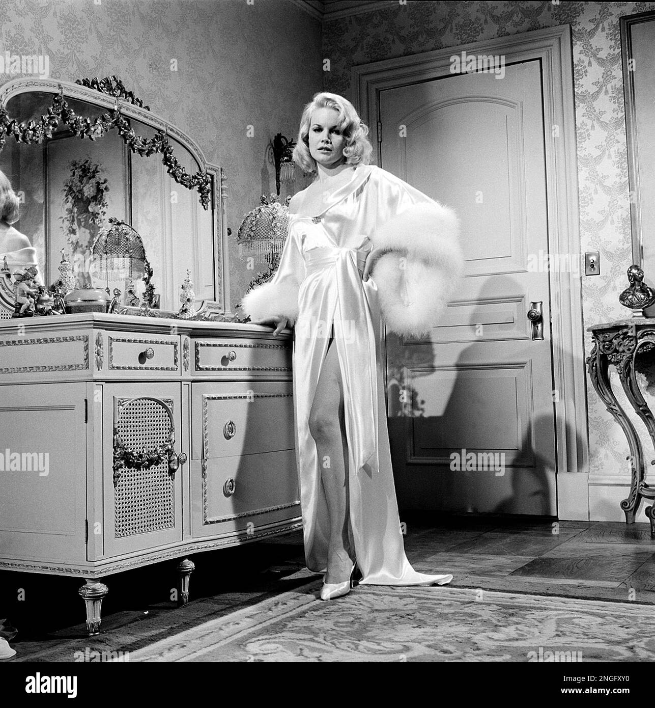 Actress Carroll Baker poses as Rina Marlow in a bedroom scene in "The Carpetbaggers" in a ...