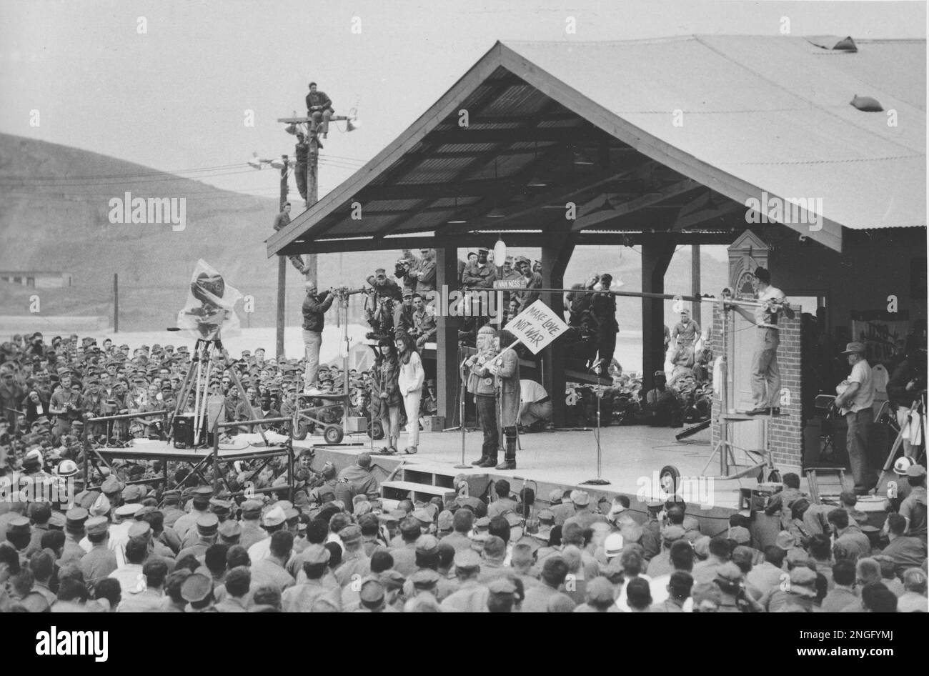 Comedian Bob Hope and singer Phil Crosby, holding a "Make Love Not War ...