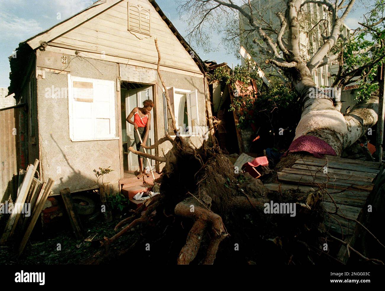 A Jamaican woman tries to clear her porch of debris in Kingston ...