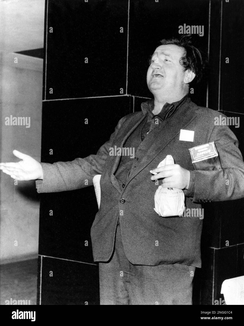 Irish playwright and poet Brendan Behan, carrying a bottle of liquor ...