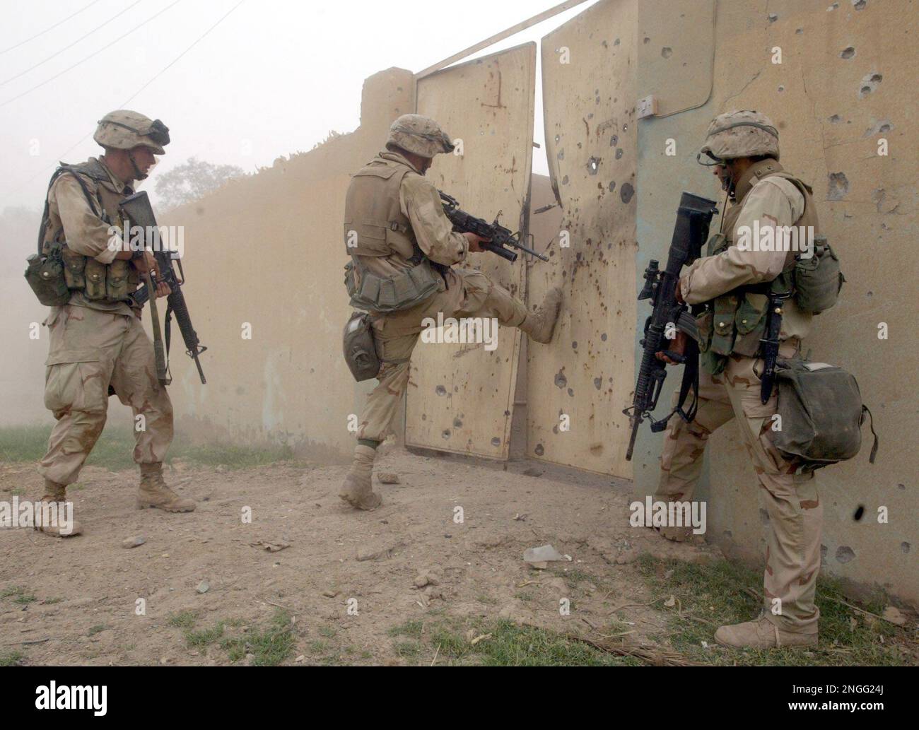 U.S. Marines of the 3rd Battalion, 4th Regiment smash a gate as they ...