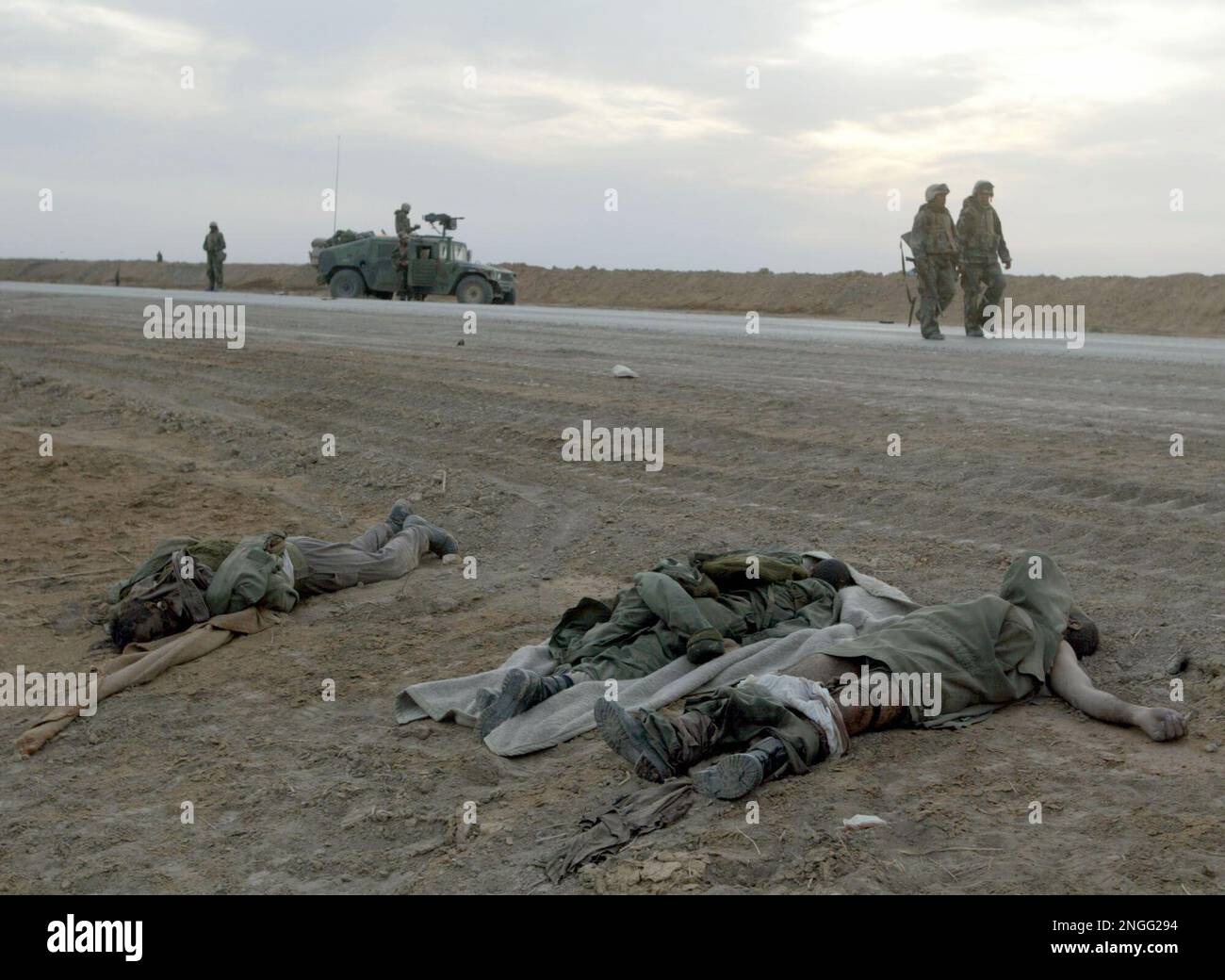 U.S. Marines of the 3rd Battalion, 4th regiment, pass by the the dead ...