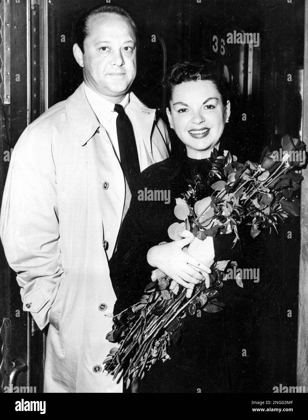 Judy Garland poses with long-stemmed roses in her arms as she is ...