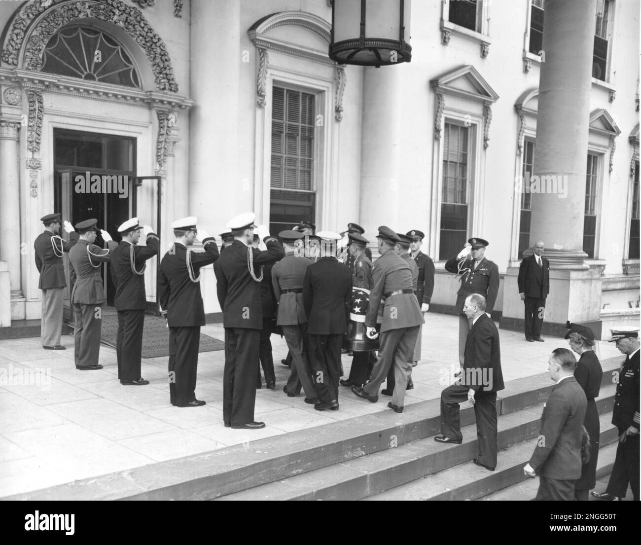 Honor guards salute the flag-draped casket bearing the body of late ...