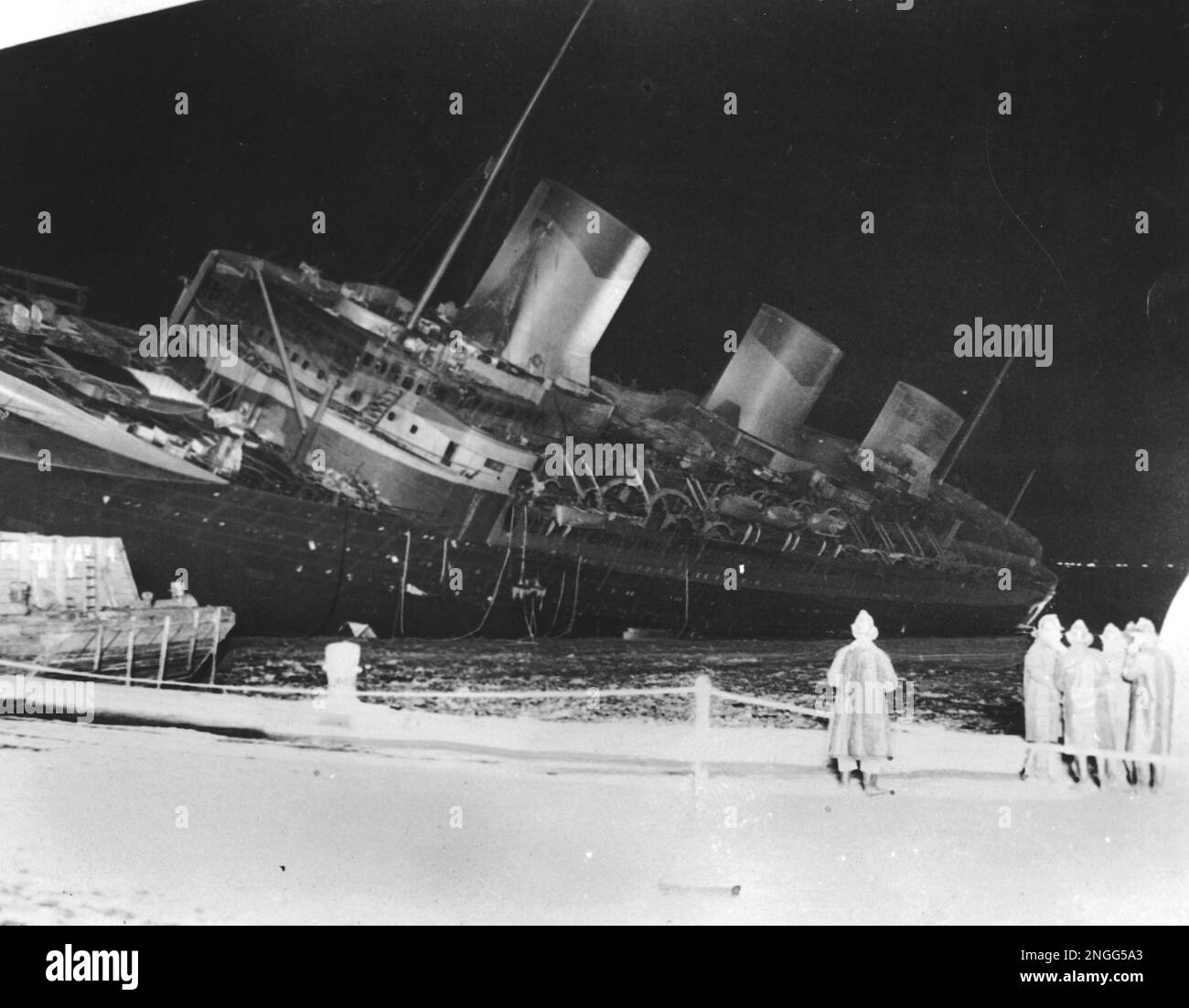 The ocean liner Normandie lies heavily tilting at New York's Pier 88 at ...