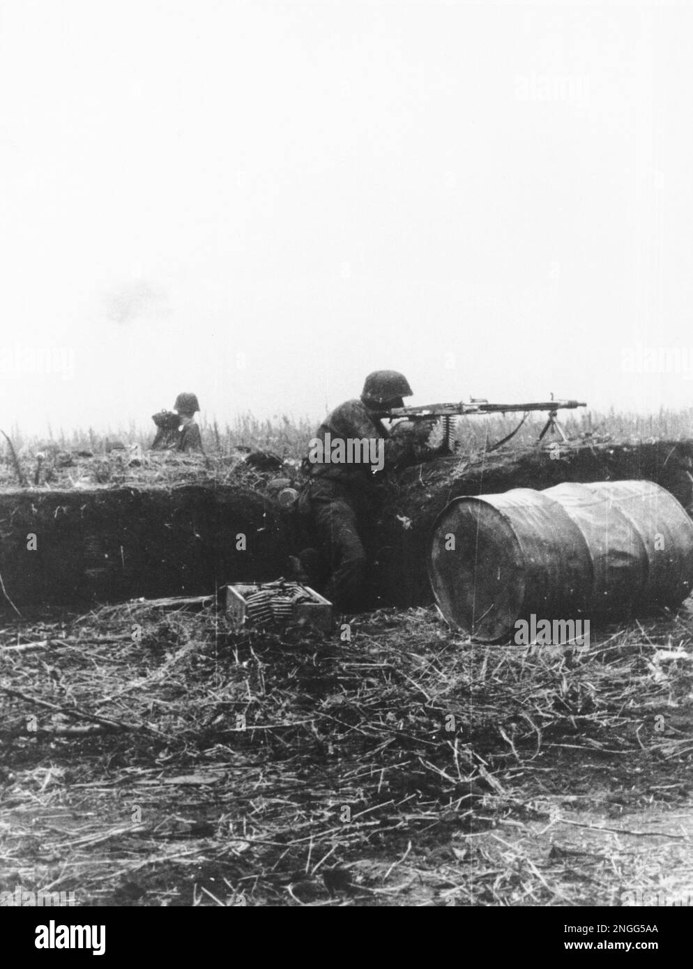 A Soviet soldier aims and fires his machine gun, at an unknown location ...