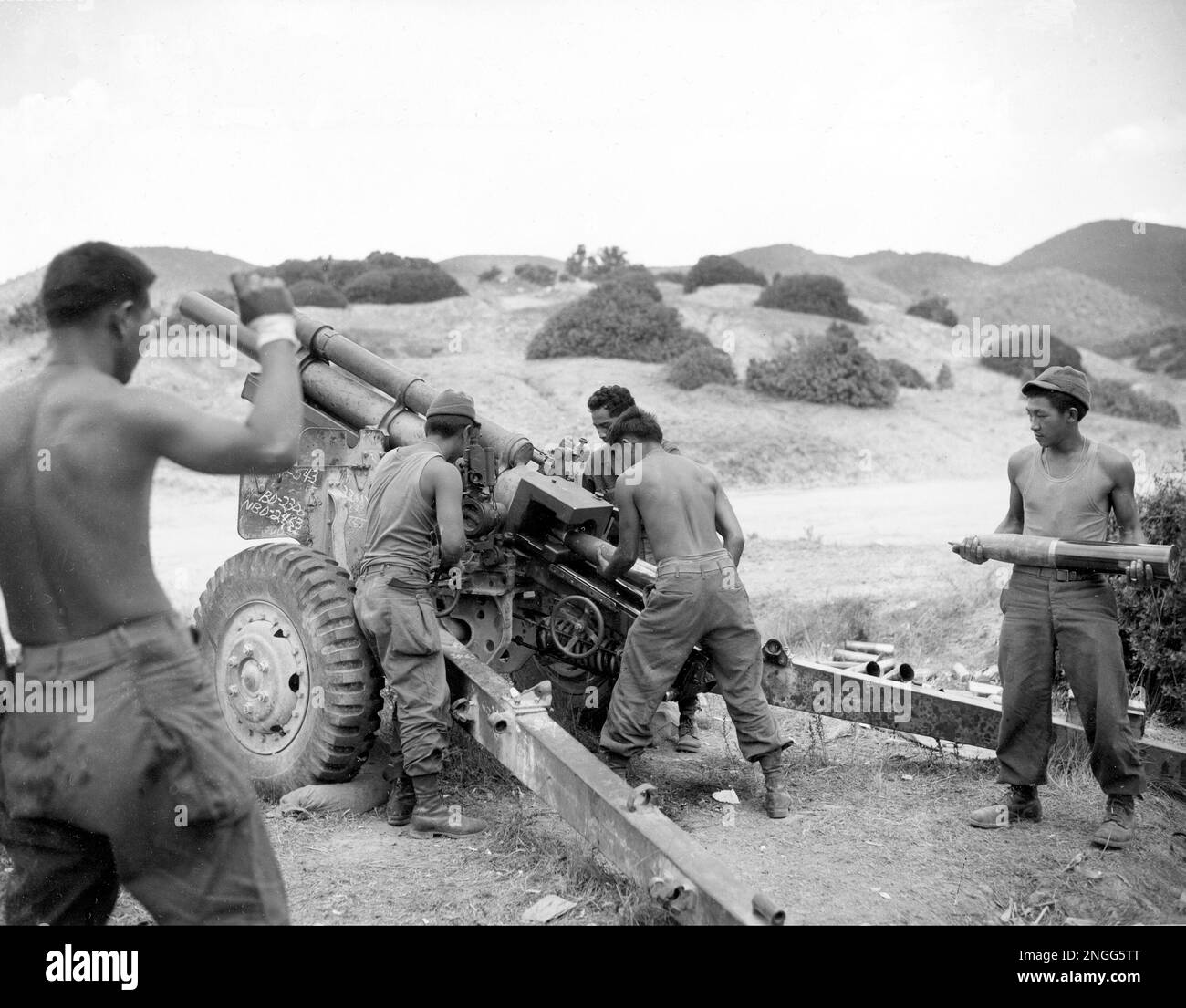 Members of a Japanese-American Howitzer Company gun crew load their ...