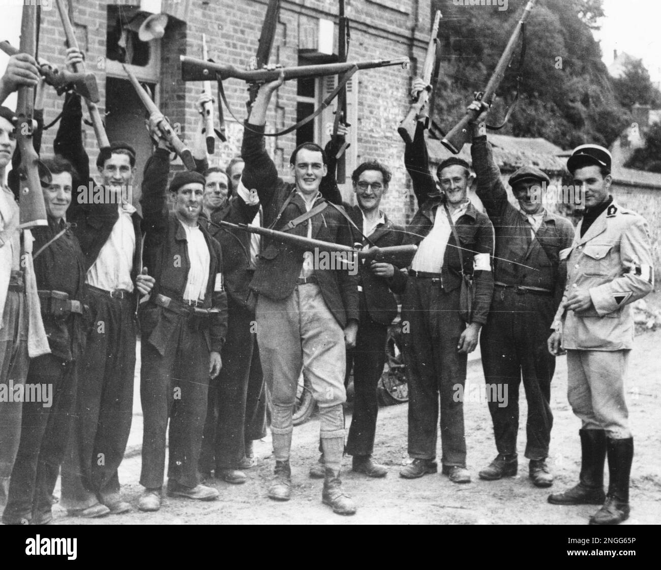 Local French Resistance fighters wave their rifles overhead as they ...