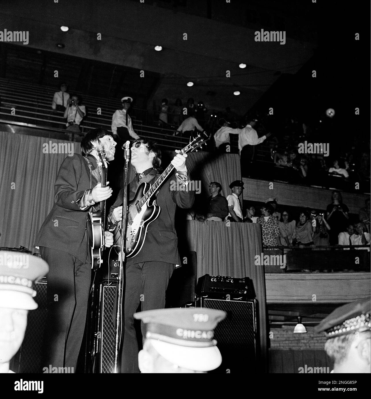 Two of the Beatles, Paul McCartney, left, on bass guitar, and John ...