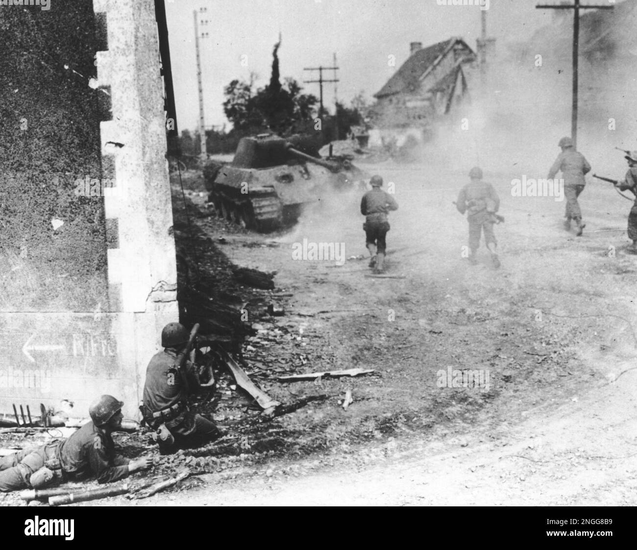 U.S. soldiers approach a smoldering German tank, after they knocked it ...