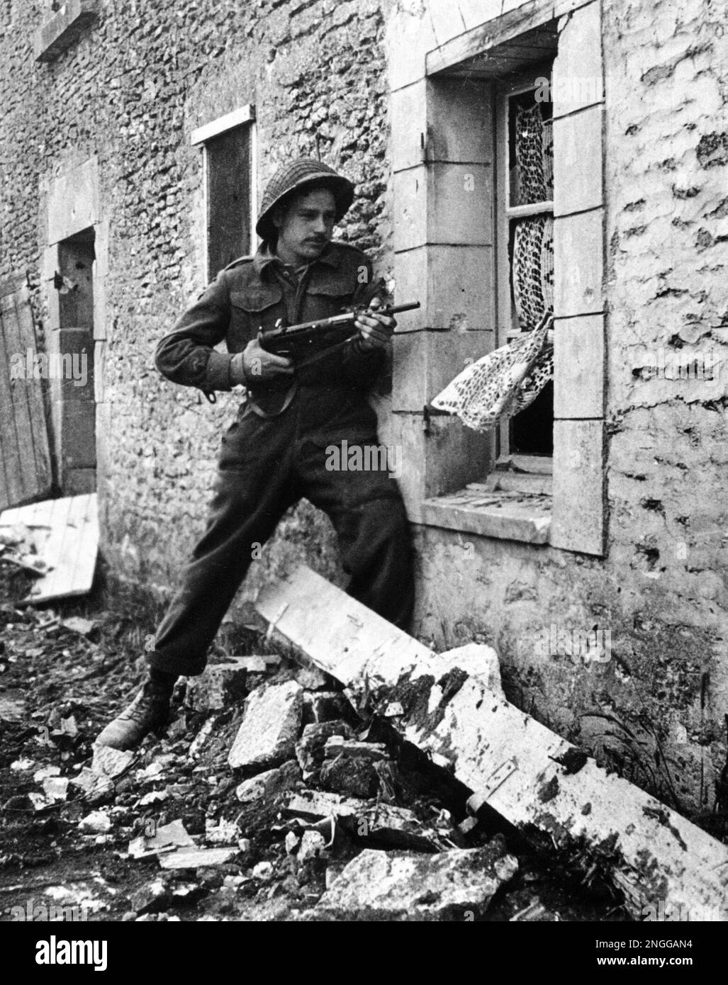 An American infantryman has his submachine gun ready as he searches for ...