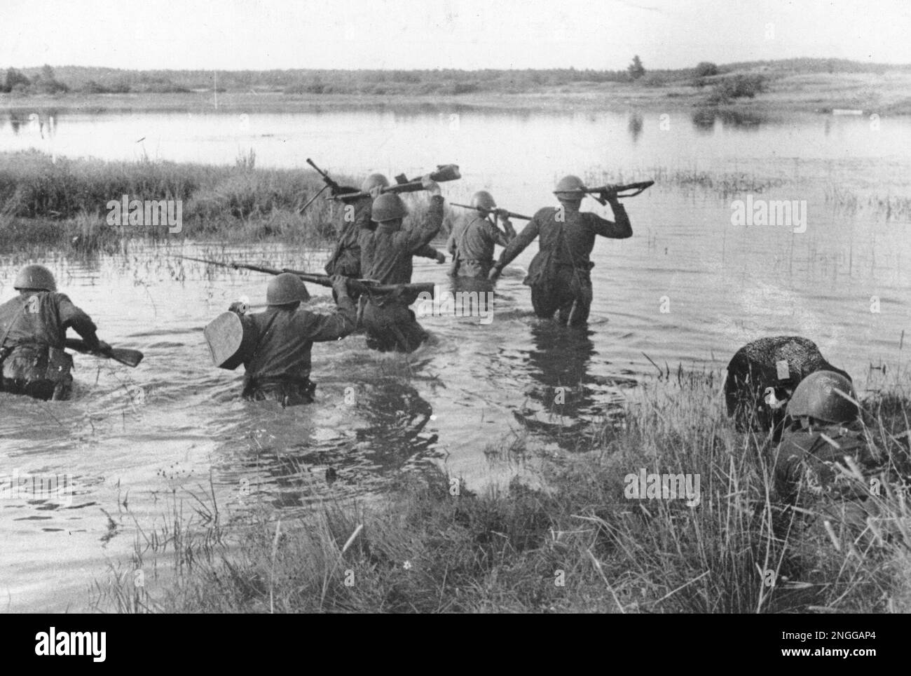 Soviet Red Army soldiers hold their rifles overhead as they wade ...