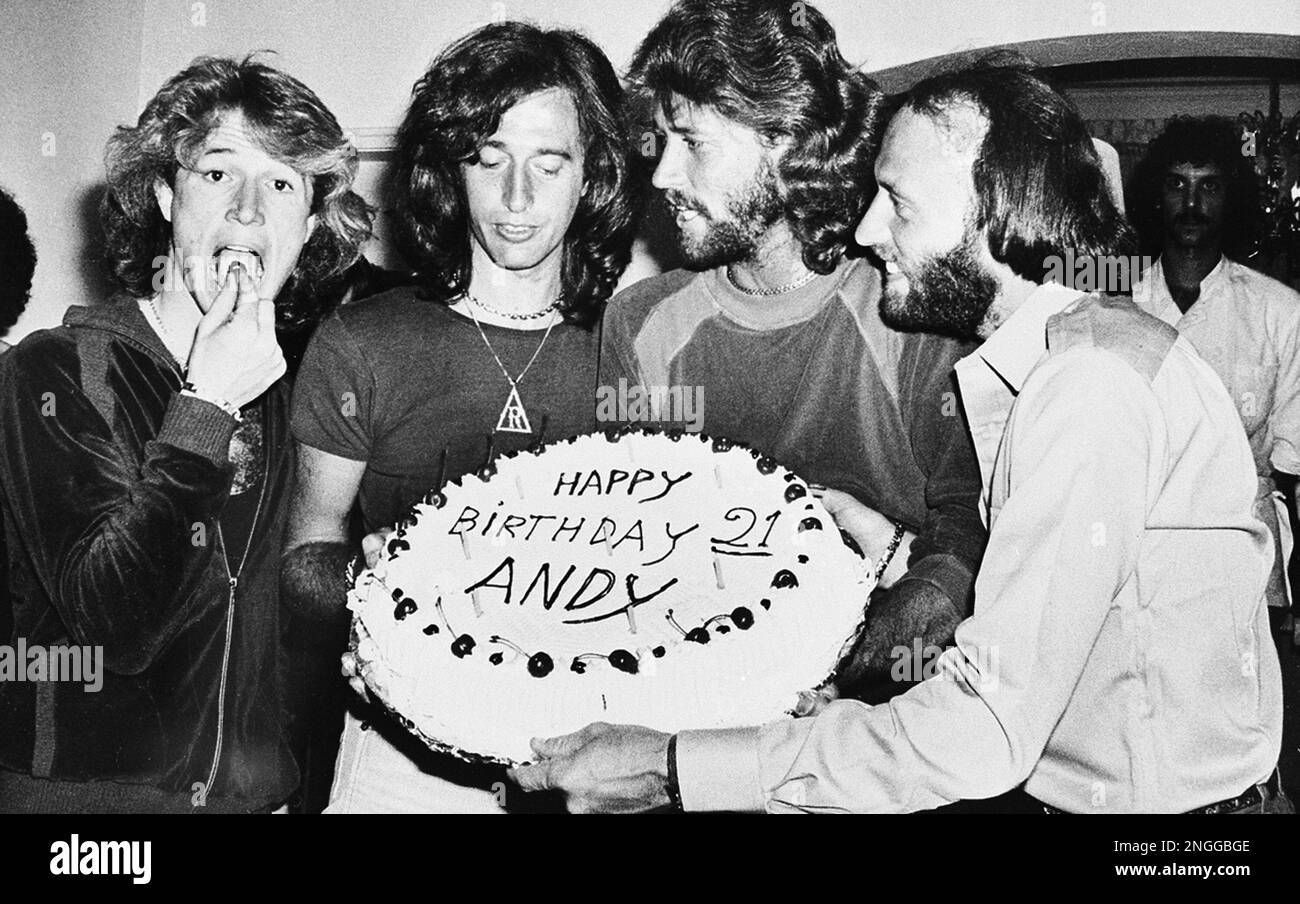 Andy Gibb eats a cherry from his birthday cake at a party given by his ...