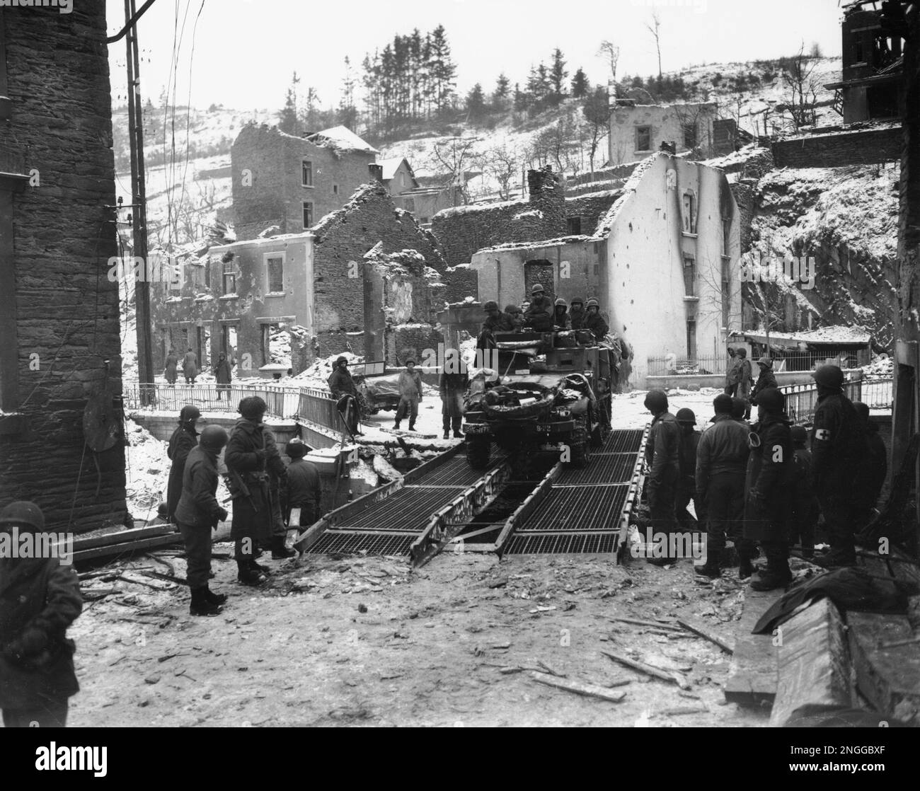 During the Battle of the Bulge, a U.S. Army half track crosses a ...