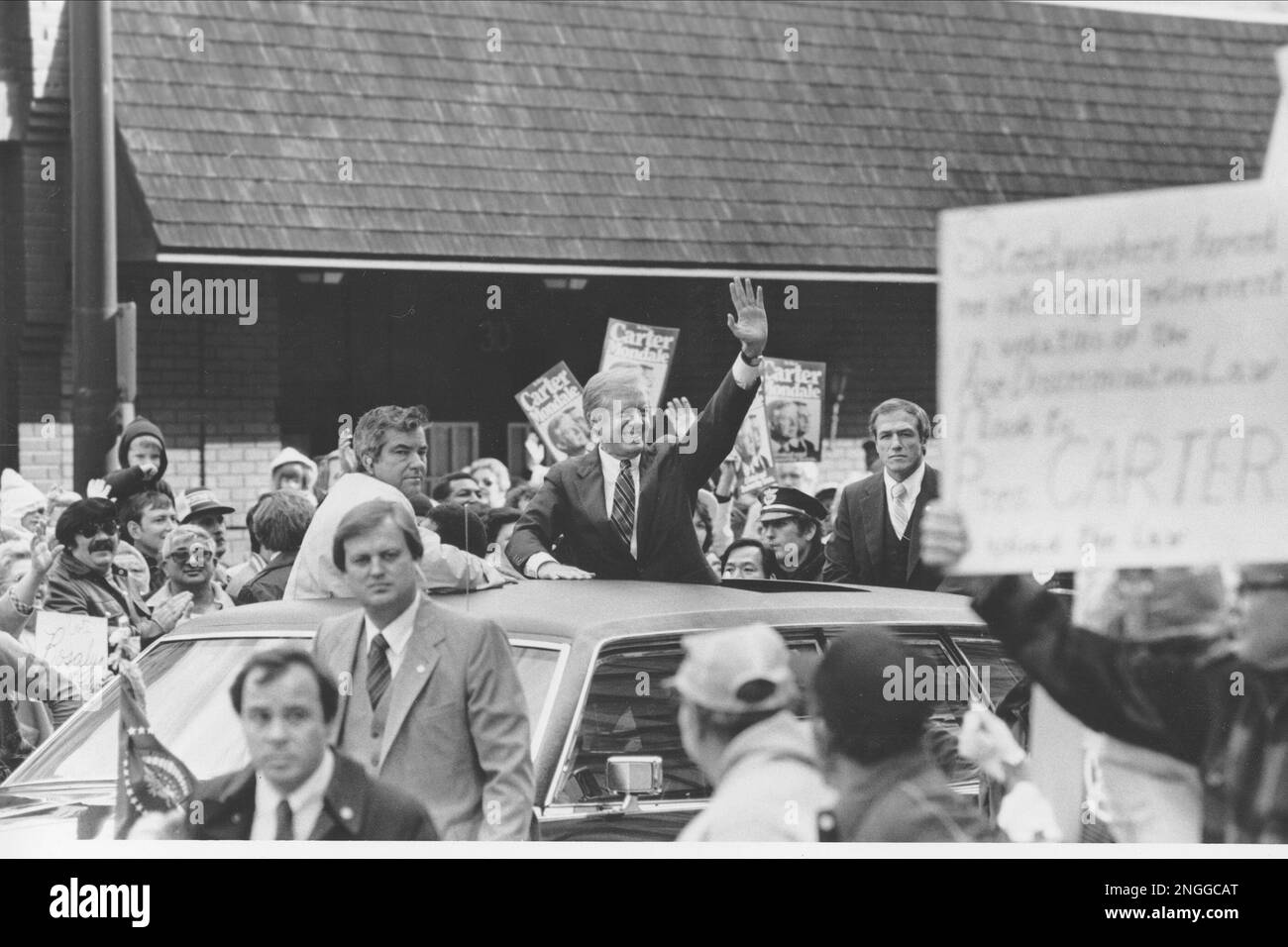 U.S. President Jimmy Carter waves to the crowd from his motorcade as ...