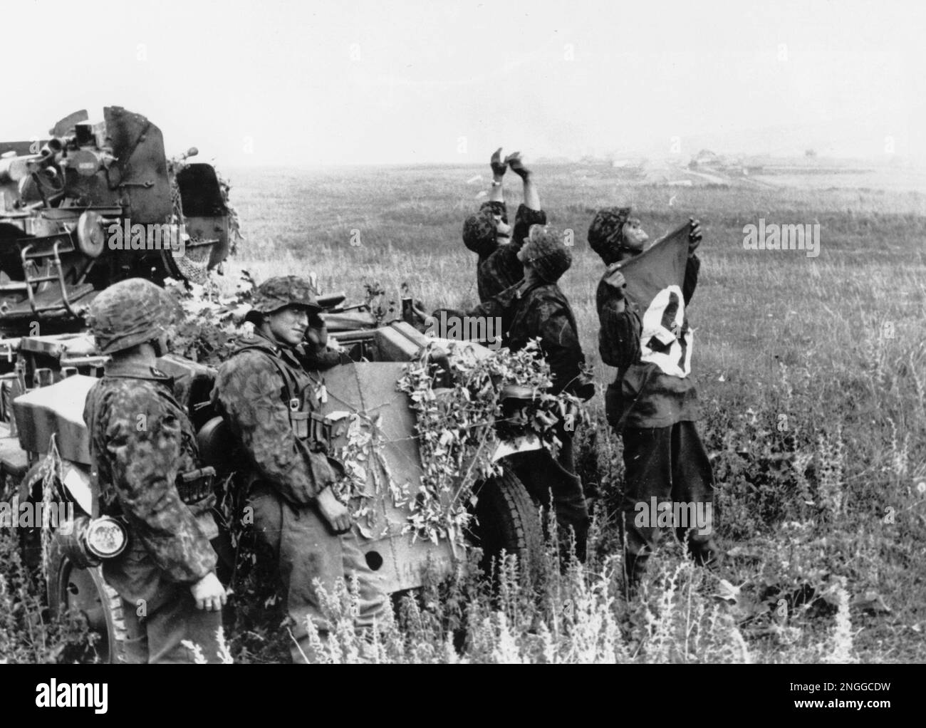 German artillerymen wave a Swastika flag to alert the Stuka bomber ...