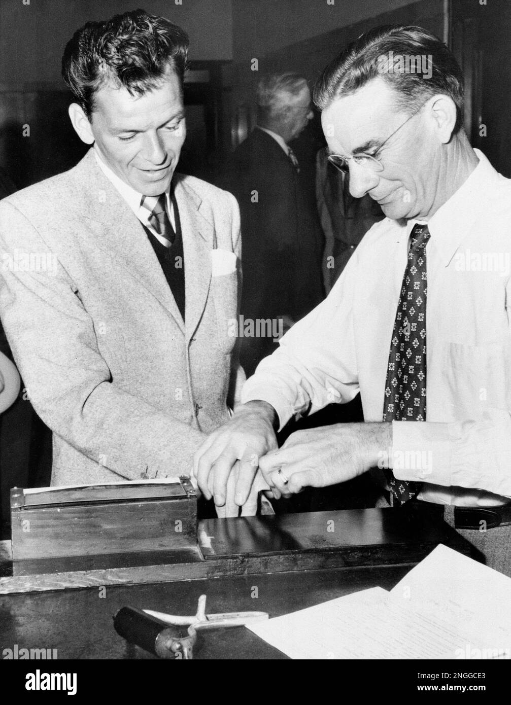 Frank Sinatra is fingerprinted by Deputy Sheriff Bob Rogers as he ...
