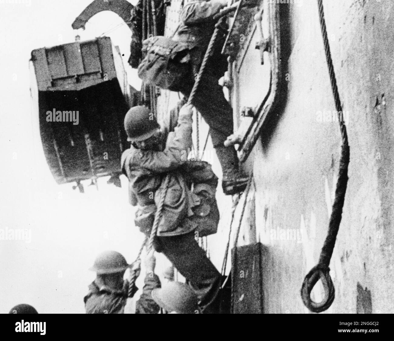 U.S. troops are seen climbing over the side of a combat transport ship ...