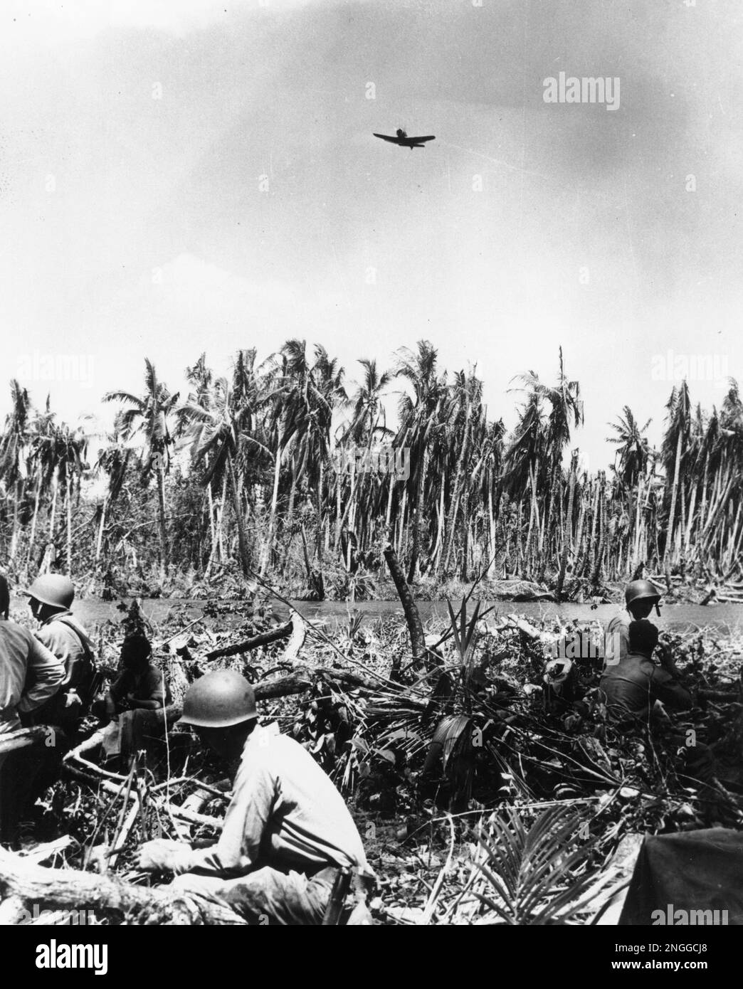 U.S. Marines sit in brushwood on "Hell's Corner," at the mouth of the ...