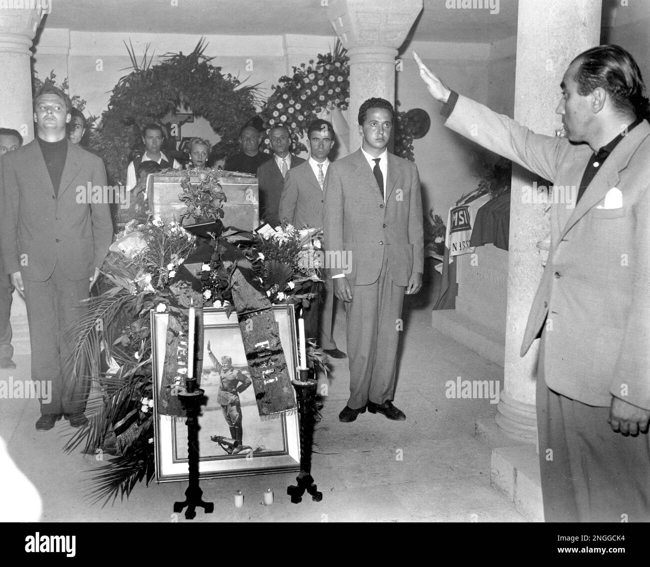 An unidentified man gives the fascist salute as young men stand to ...