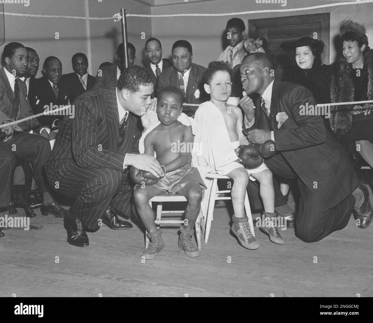 Heavyweight boxing champion Joe Louis, left, whispers advice to six ...