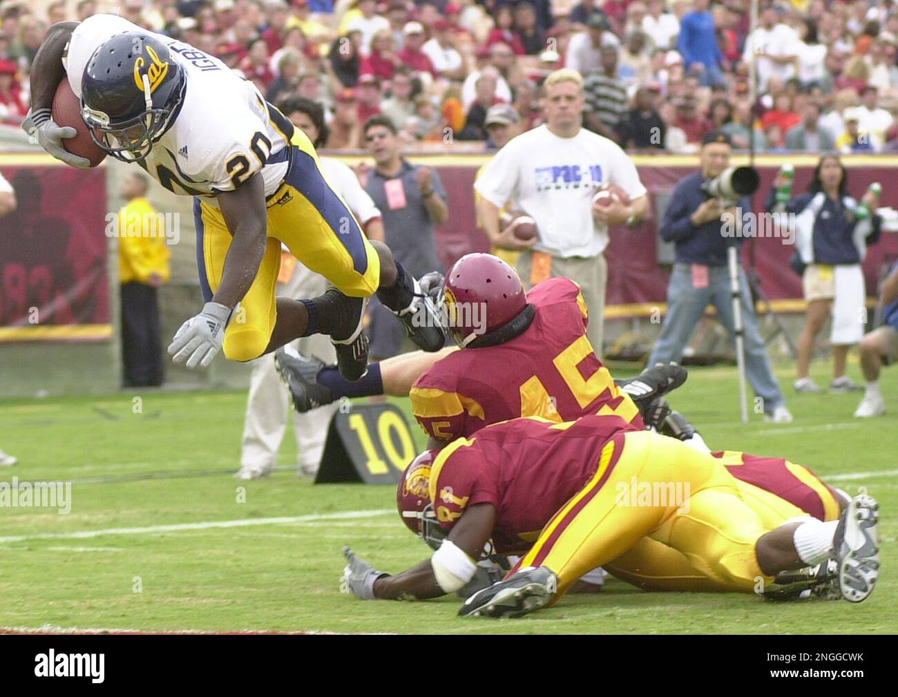 California's Joe Igber dives over Southern Cal's Mike Pollard (45) and ...