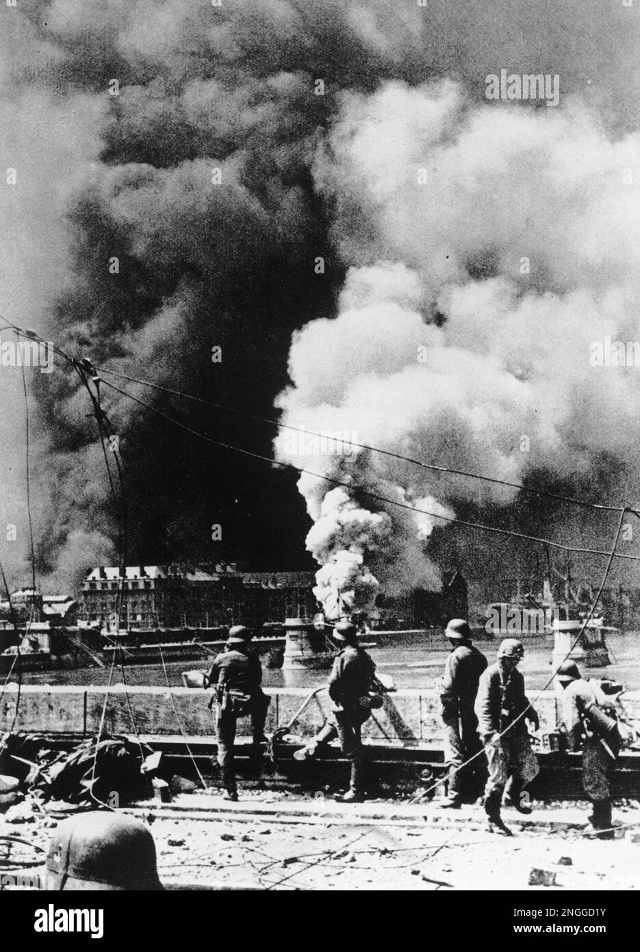 Standing on the banks of the Maas river, German soldiers watch from a ...