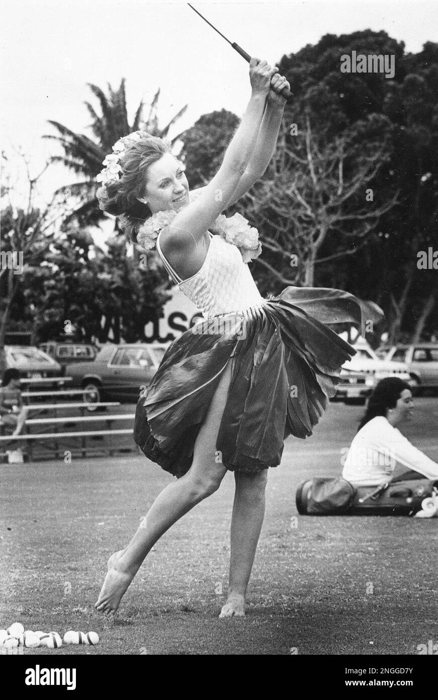 Jan Stephenson, barefoot in Hawaiian leaf skirt ensemble, is shown ...