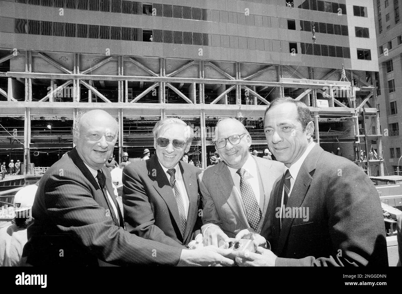 Officials join together to press a button to raise the final beam ...