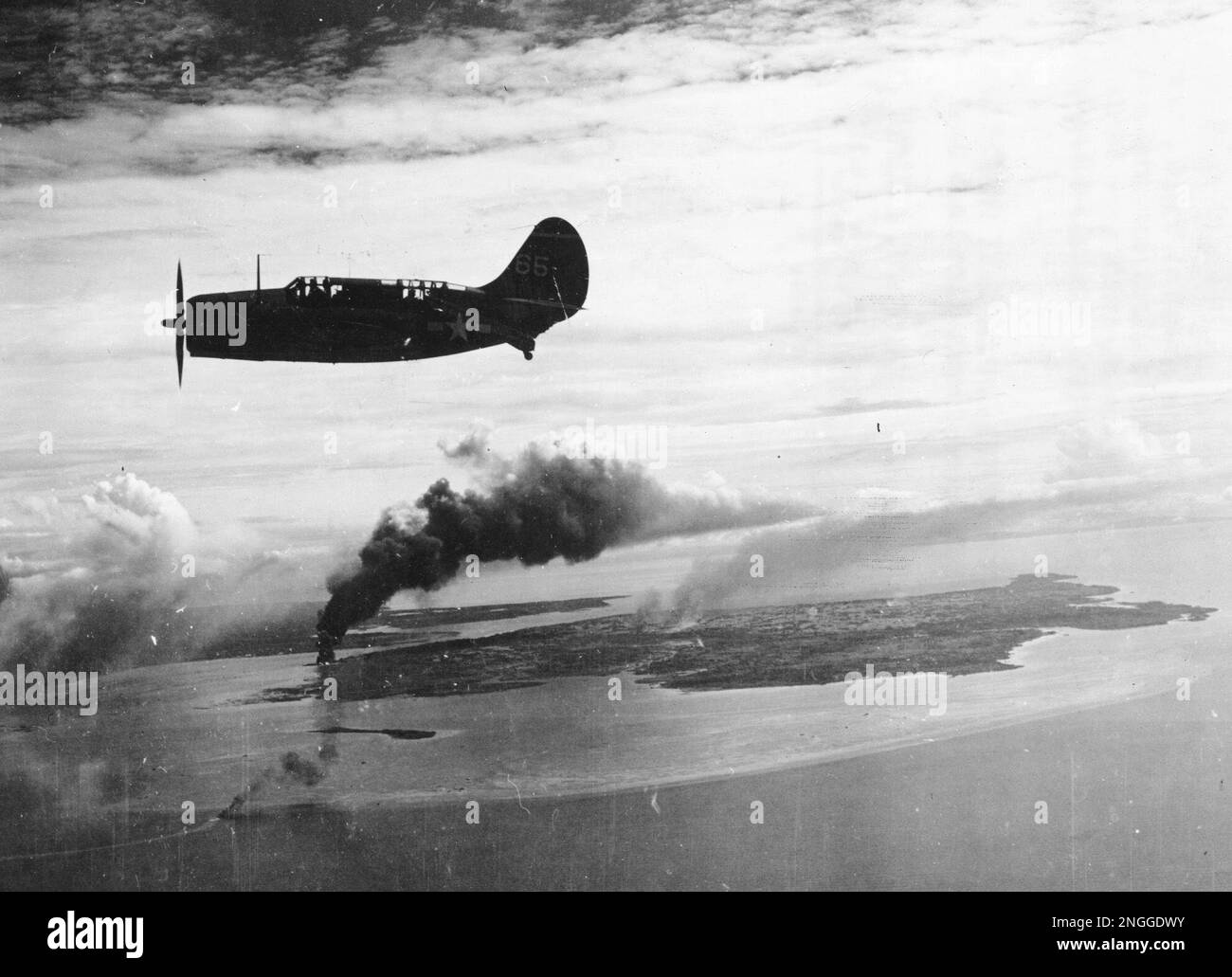 A Curtiss Helldiver returns to its base on a U.S. Navy carrier, leaving ...