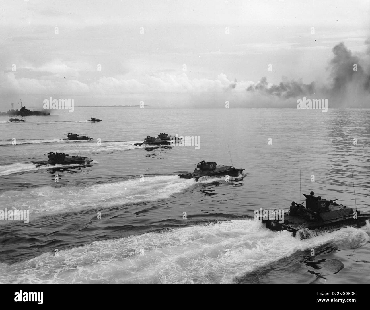 Amphibious tanks with turret housed cannons churn through the sea bound ...