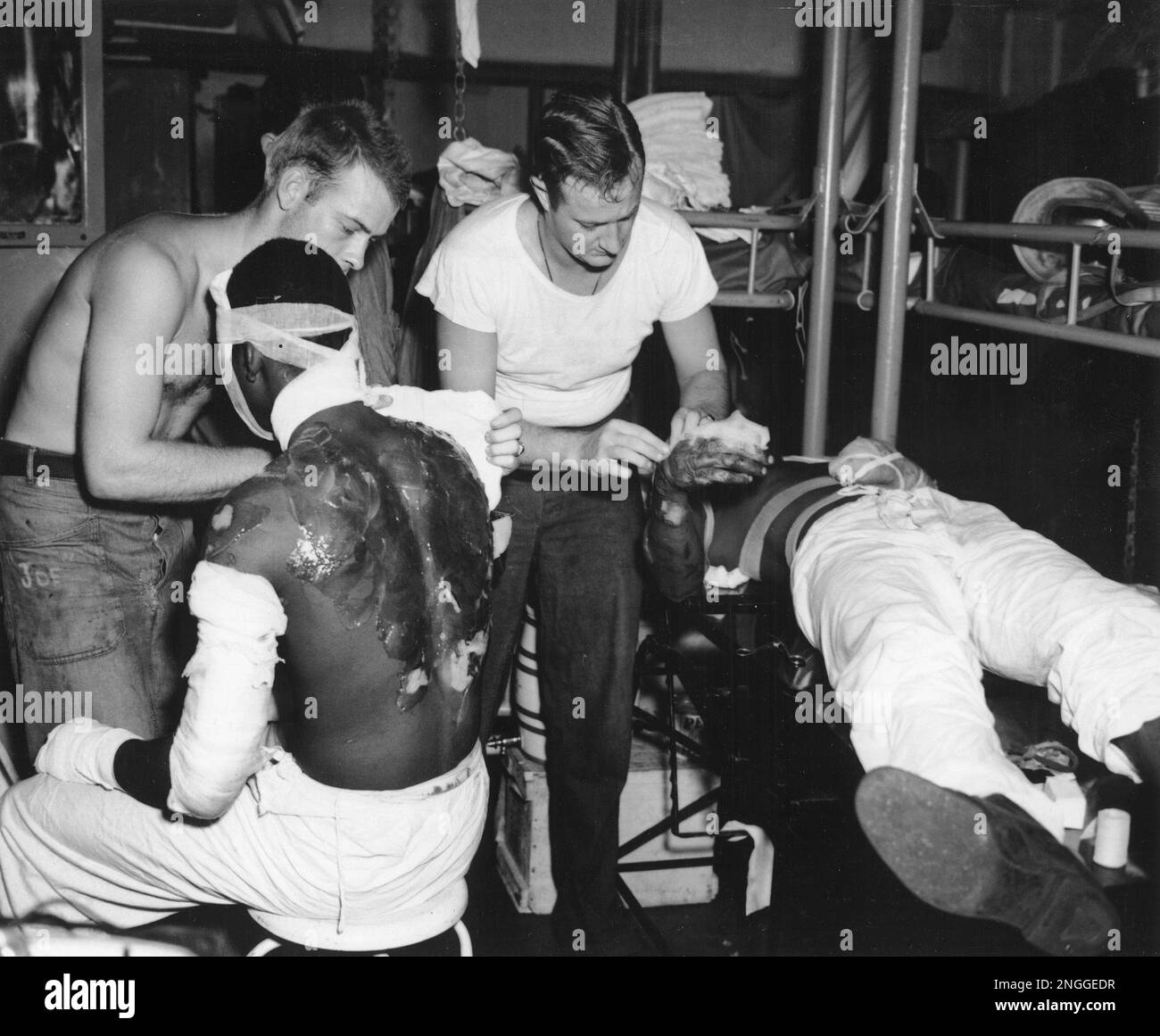 Two wounded U.S. Navy crewmen are given medical attention aboard the ...