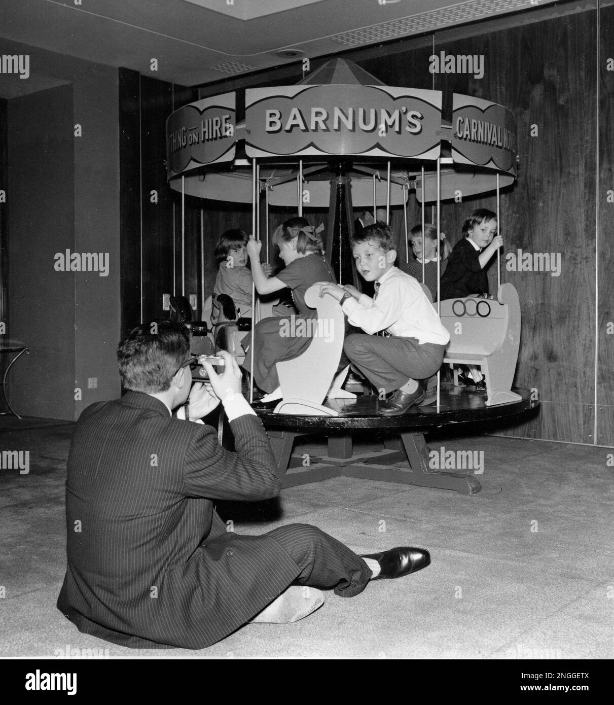 British actor Peter Sellers sits on the floor to take a picture of his ...