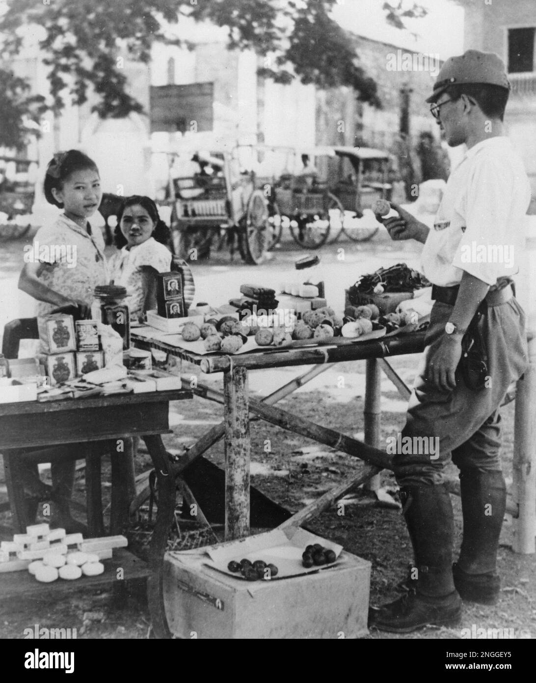A Japanese officer is bargaining at a roadside stand somewhere in the ...