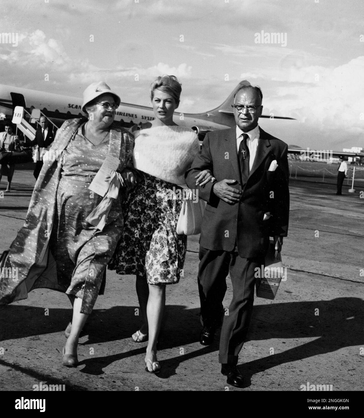 Swedish-born actress Anita Ekberg links arms with her mother and father ...