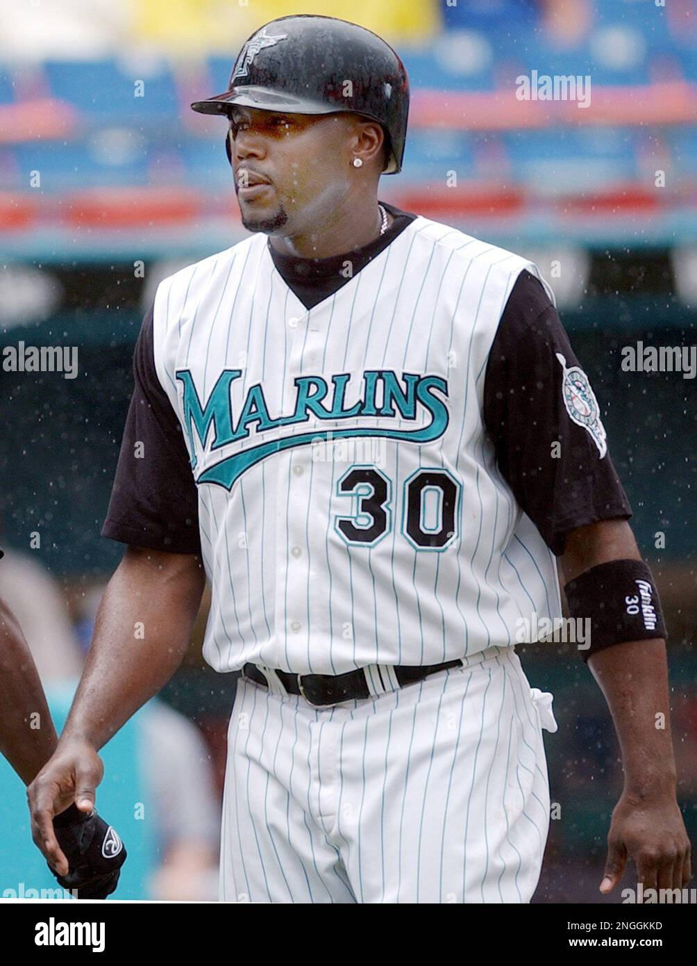 Florida Marlins' Cliff Floyd walks to the dugout after scoring on a ...