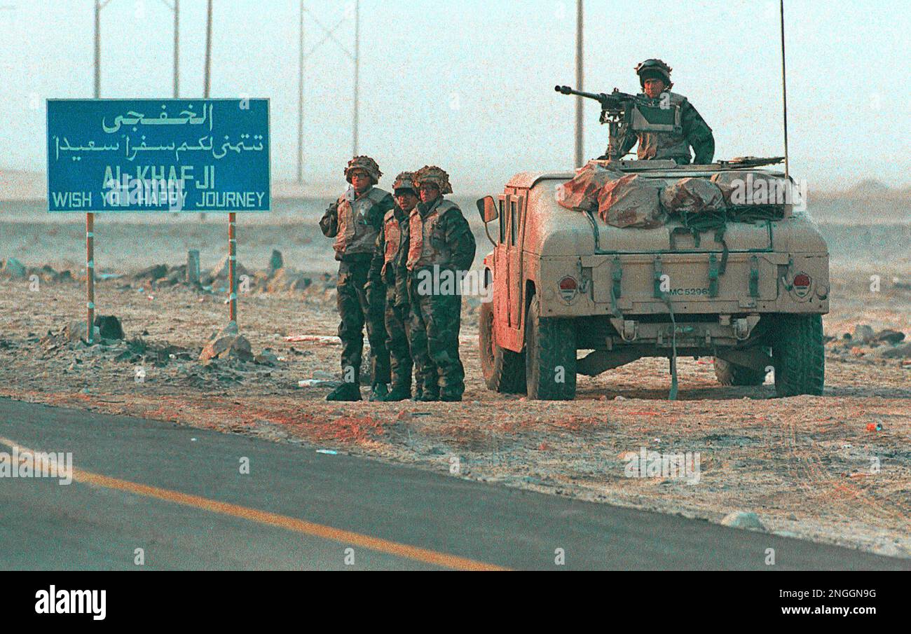 American Marines stand beside their humvee next to a road sign greeting ...