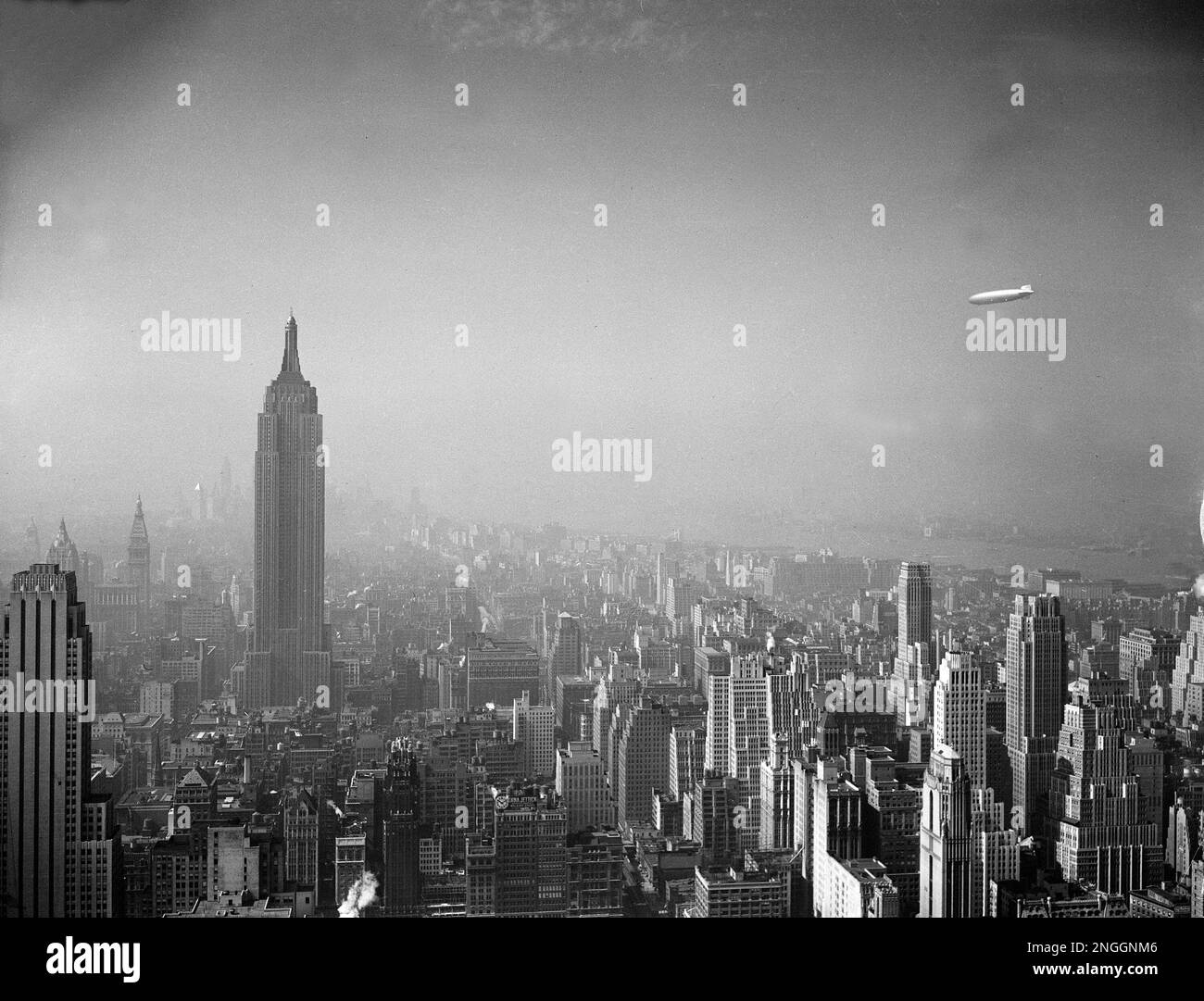The German-built zeppelin Hindenburg, right, floats over the Manhattan ...